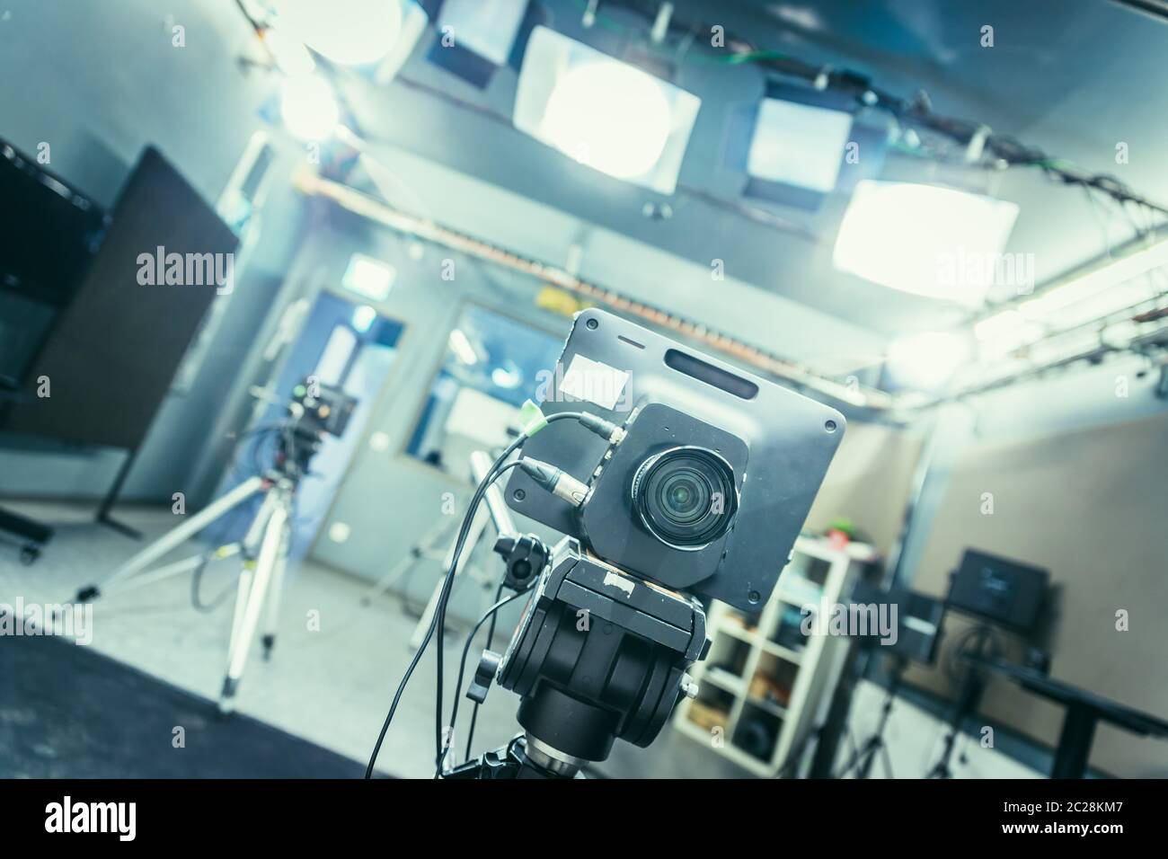 Film camera in broadcasting studio, spotlights and other equipment ...