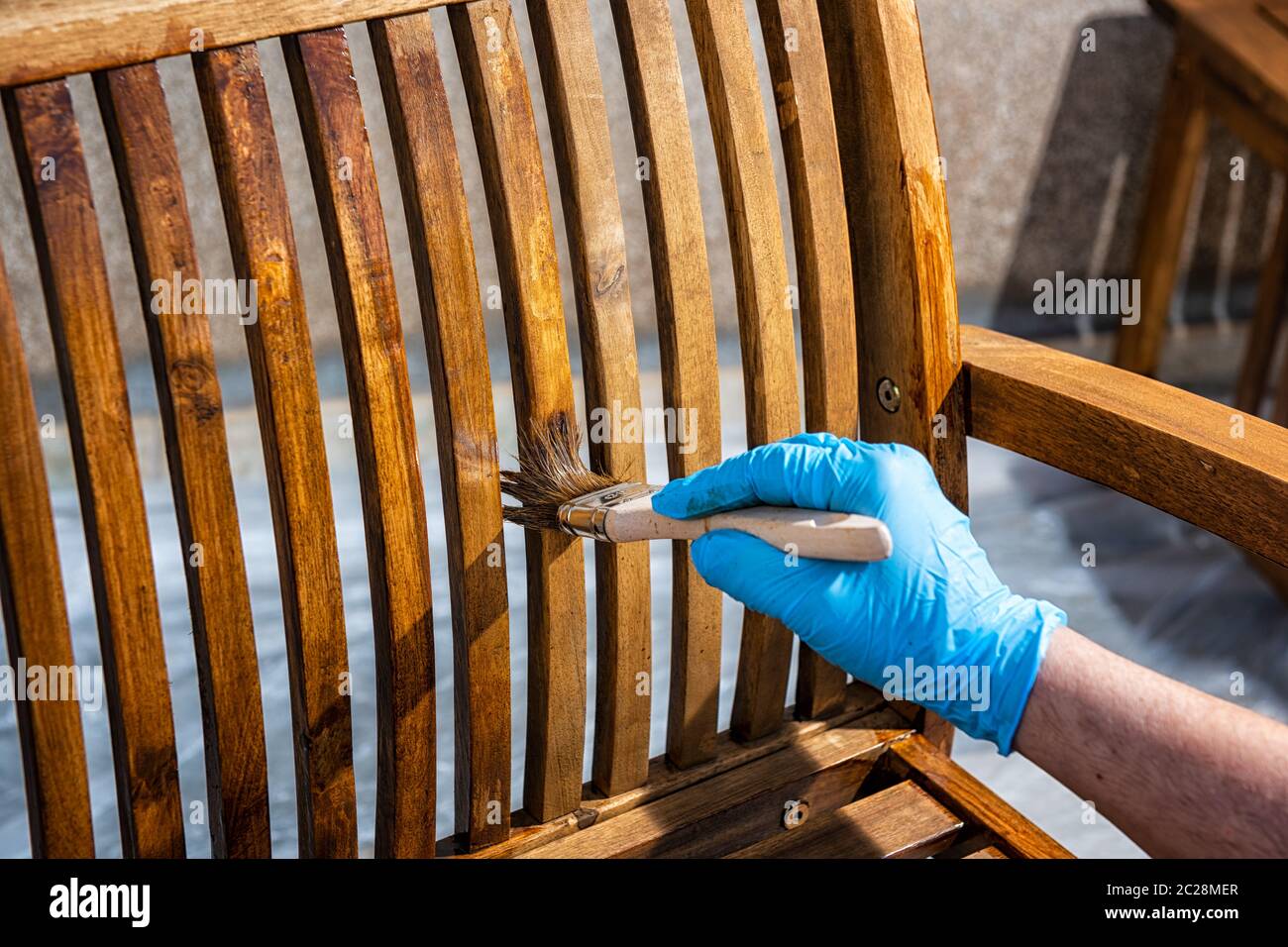 Adult carpenter craftsman painting with water-based paint the strips of ...