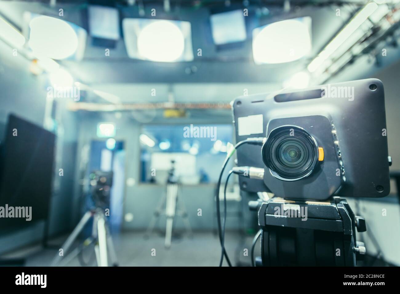 Film camera in broadcasting studio, spotlights and other equipment ...