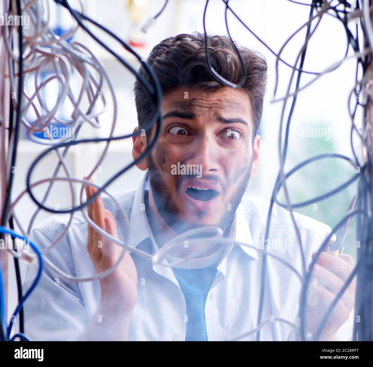 Electrician trying to untangle wires in repair concept Stock Photo - Alamy