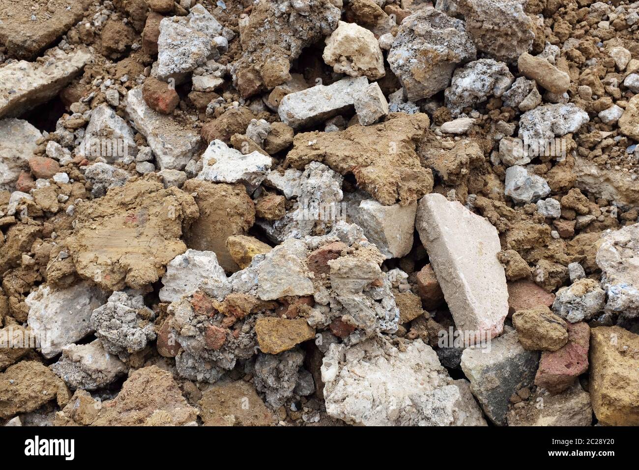 Rough heap of broken concrete, bricks and paving slabs mixed with lumps ...