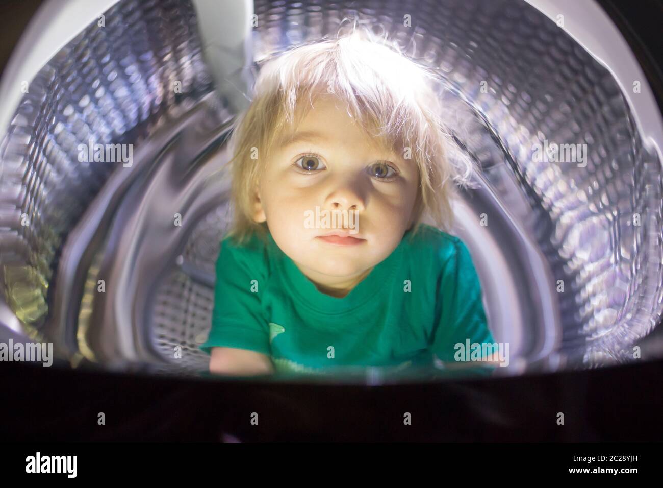 Happy child, sitting in thumble dryer, smiling happily Stock Photo - Alamy