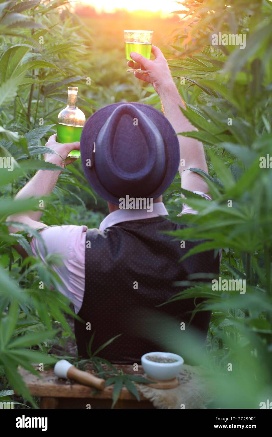 A man pours hemp wine from a bottle Stock Photo - Alamy