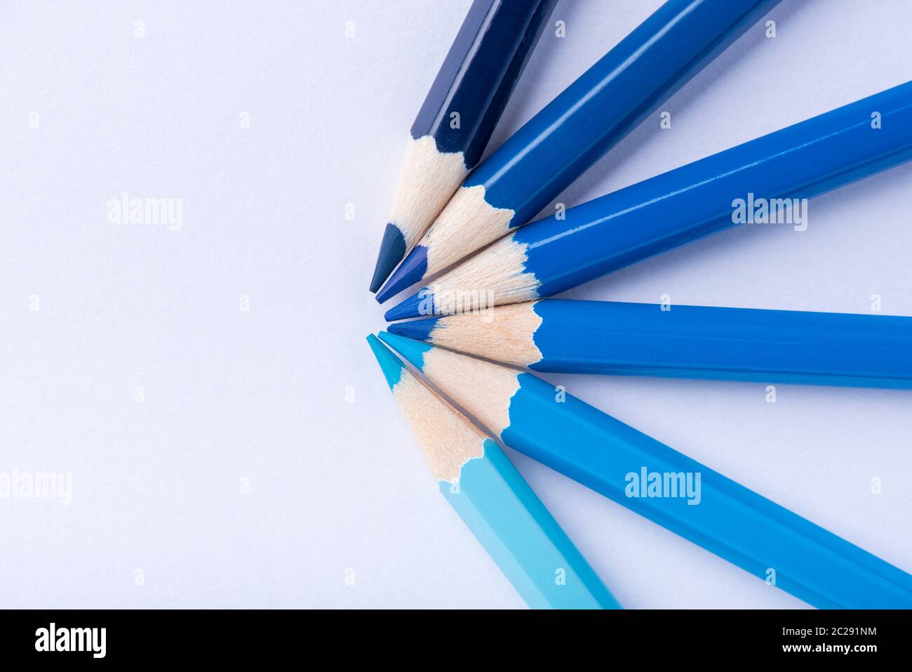 Macro photograph of several sharpened pencils of blue color on a white ...