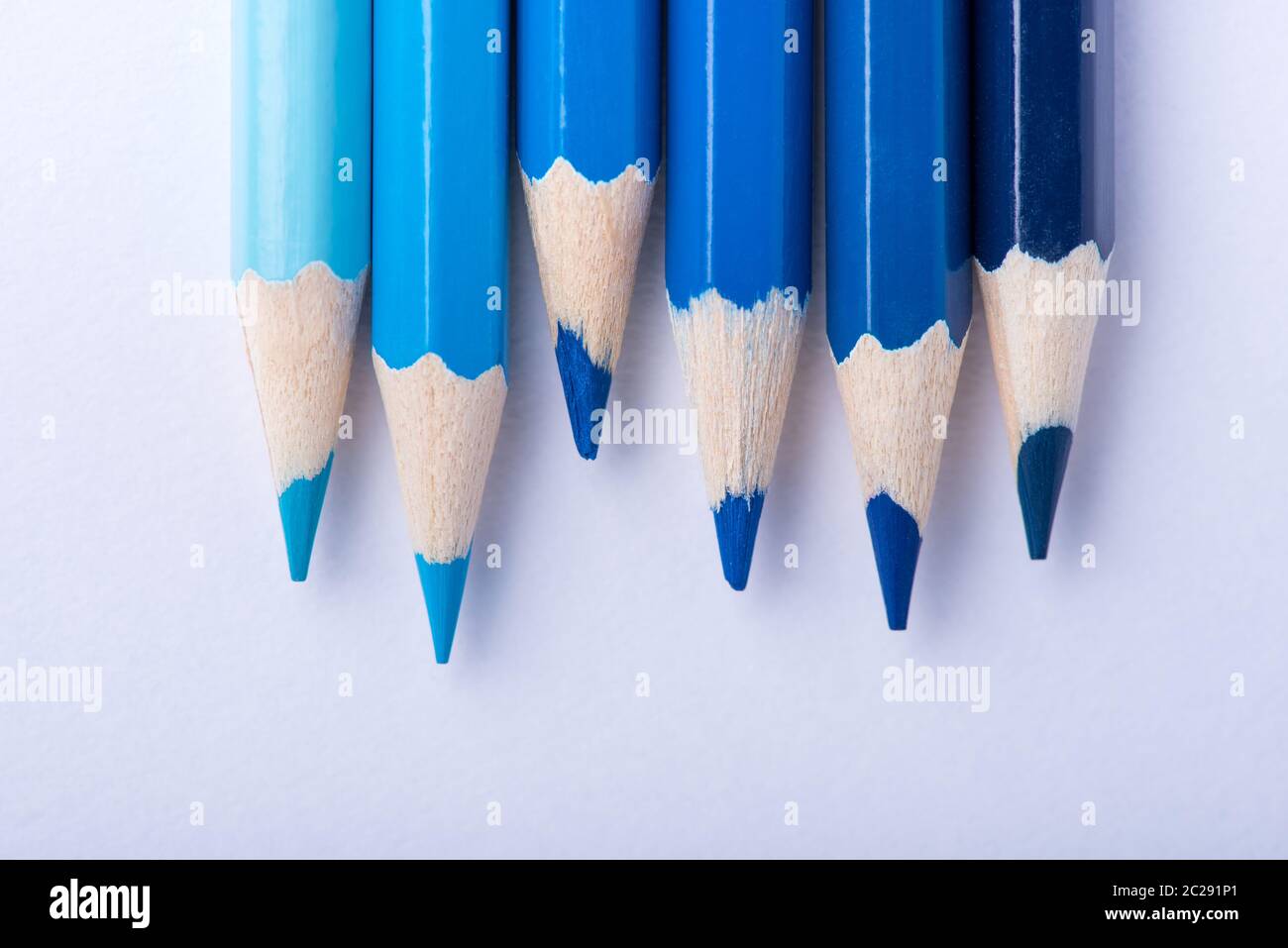 Macro photograph of several sharpened pencils of blue color on a white ...