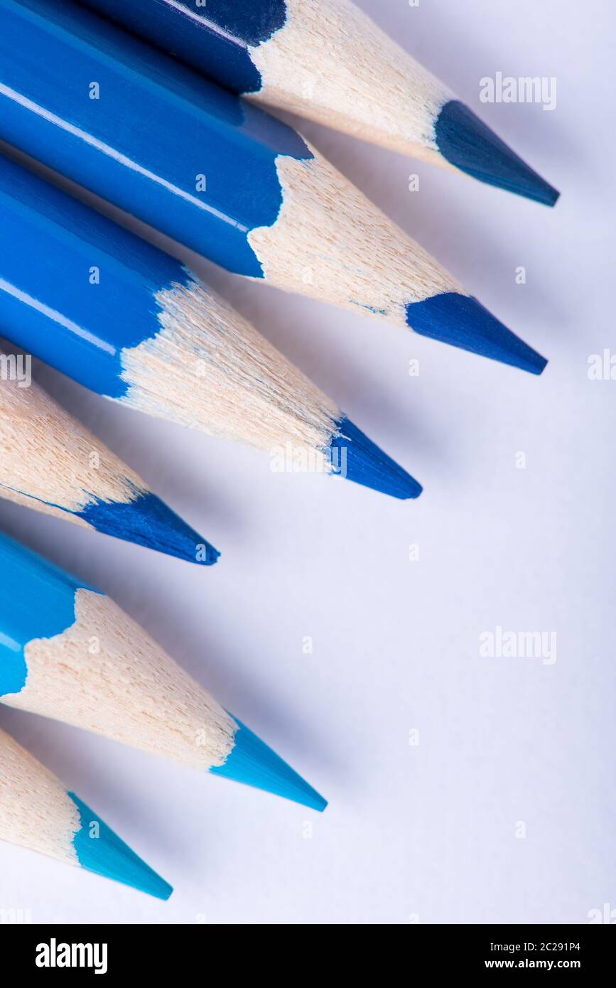 Macro photograph of several sharpened pencils of blue color on a white ...