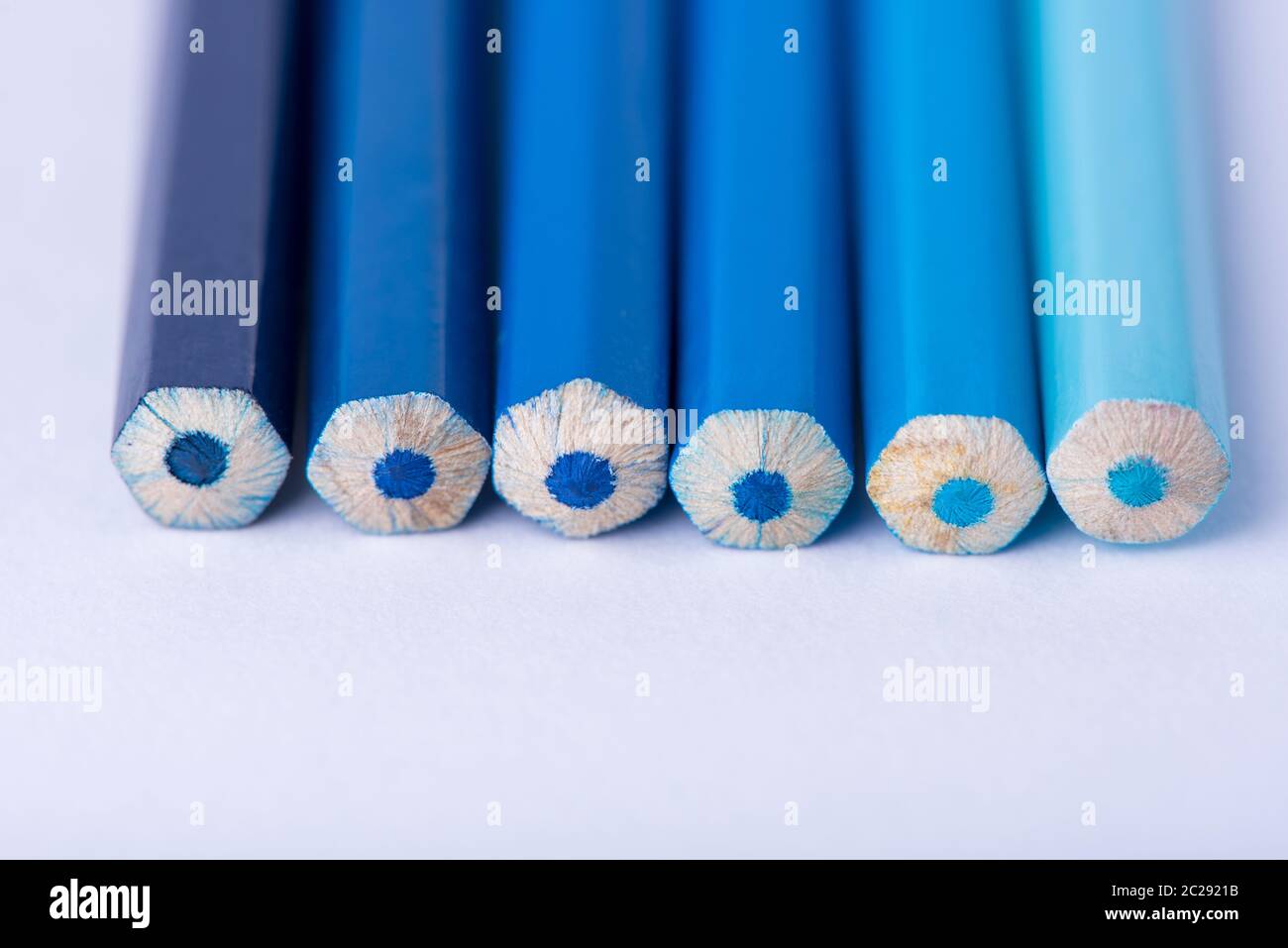 Macro photograph of several sharpened pencils of blue color on a white ...
