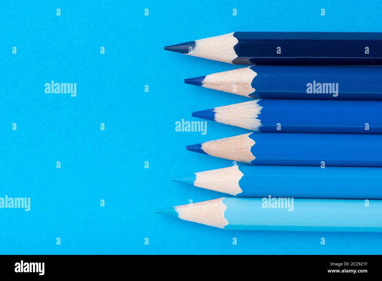 Macro photograph of several sharpened pencils of blue color on a paper ...