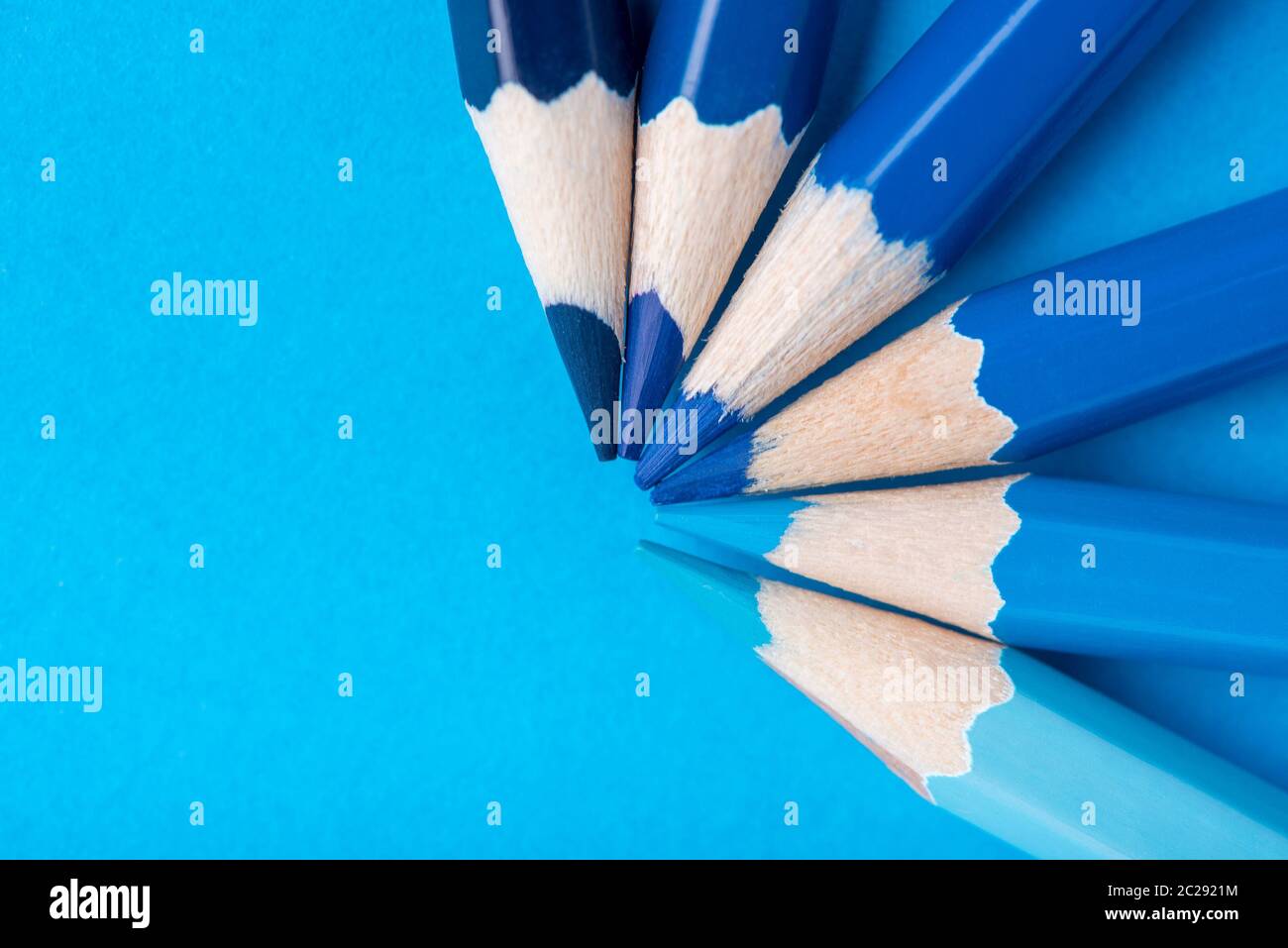 Macro photograph of several sharpened pencils of blue color on a paper ...