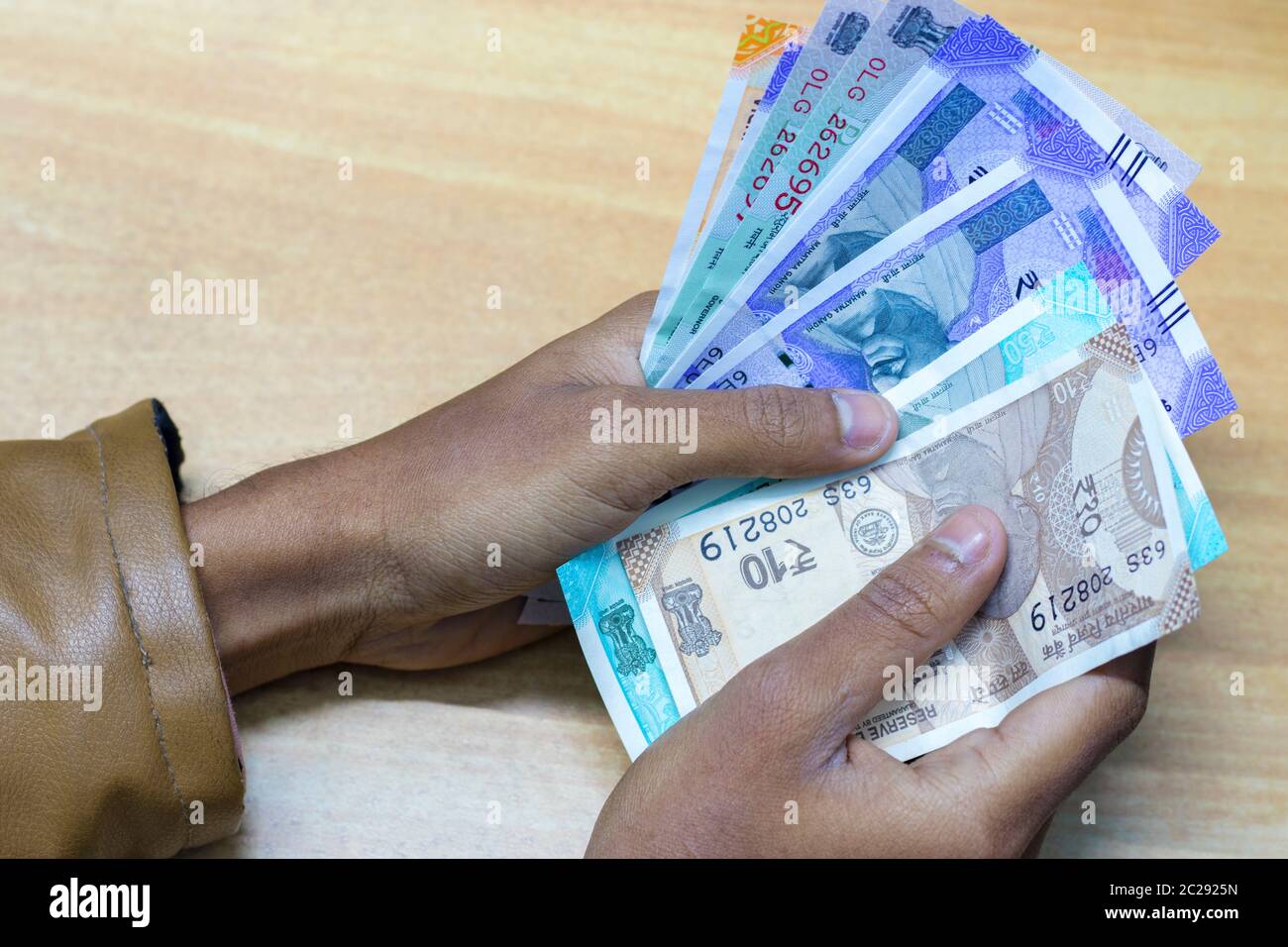 closeup view of a man counting Indian currency Stock Photo - Alamy