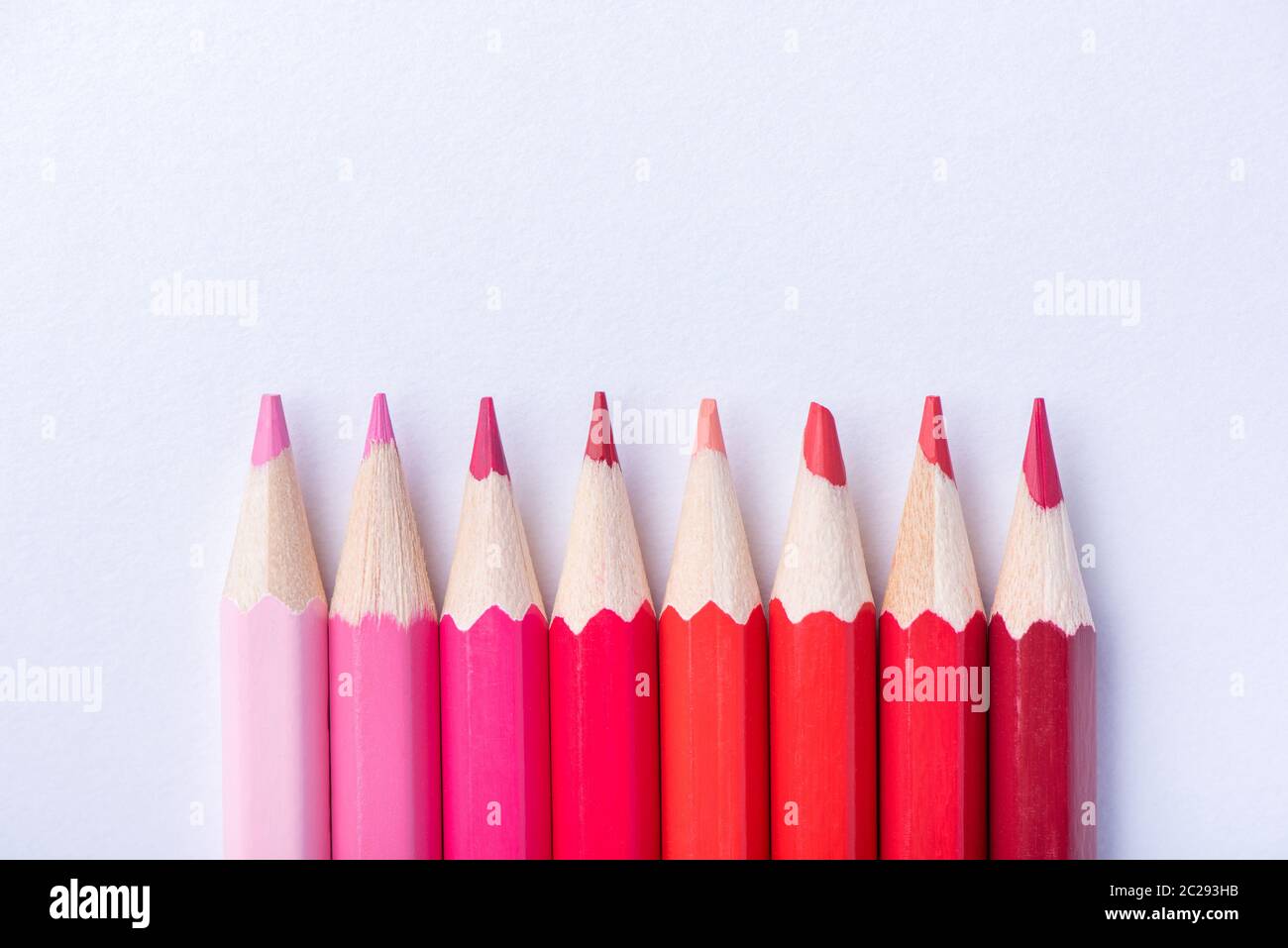 Macro photograph of several sharpened pencils of red color on a white ...