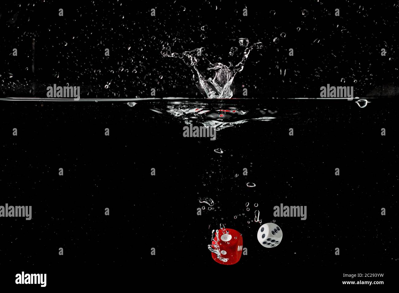 Ludo dice in water splash on black background with lots of air bubbles ...