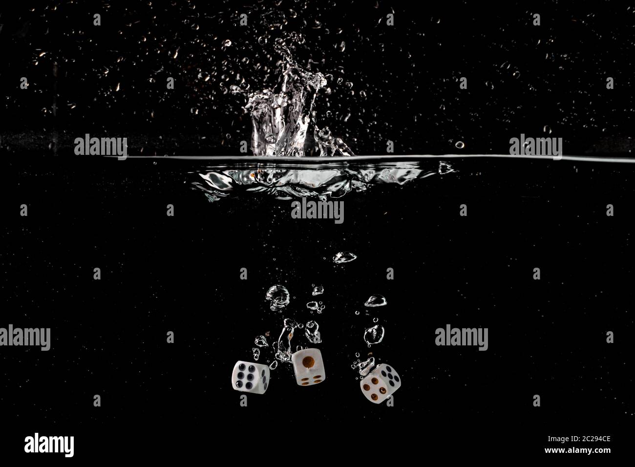 Ludo dice in water splash on black background with lots of air bubbles ...