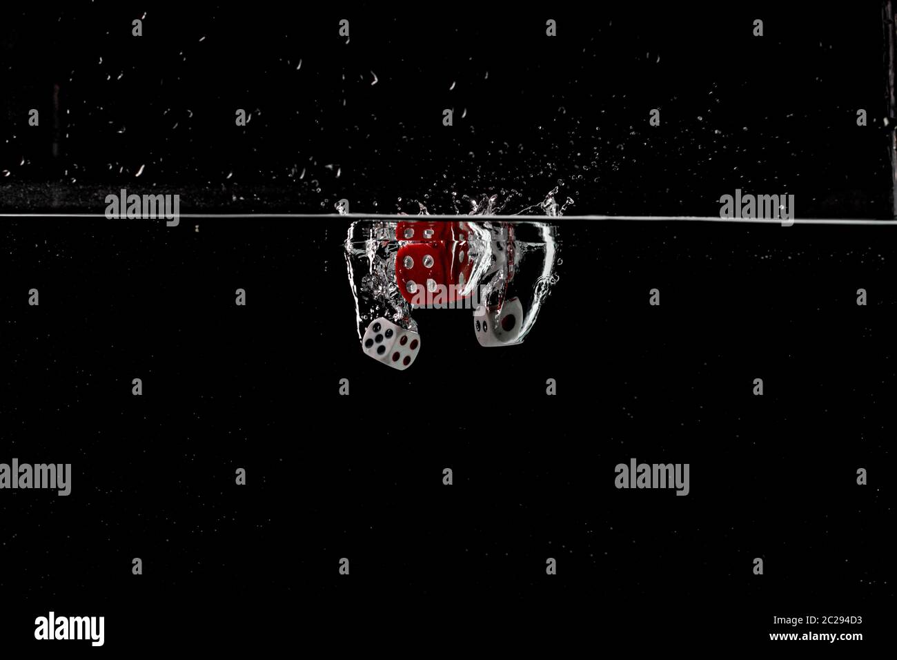 Ludo dice in water splash on black background with lots of air bubbles ...