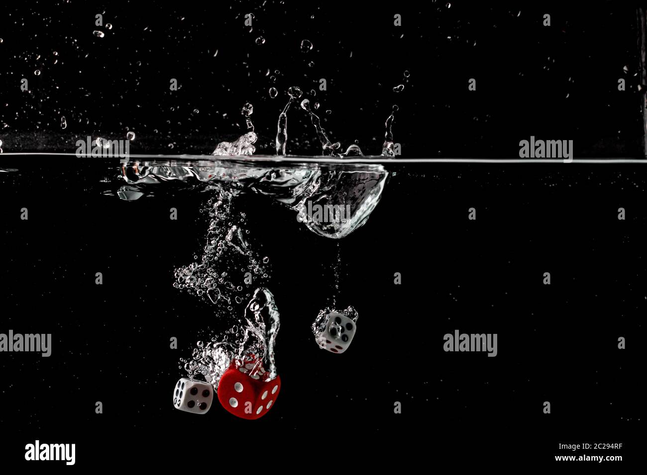 Ludo dice in water splash on black background with lots of air bubbles ...