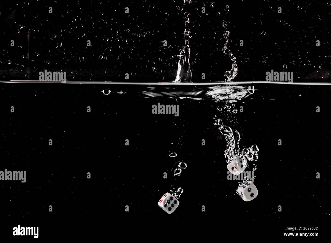 Ludo dice in water splash on black background with lots of air bubbles ...