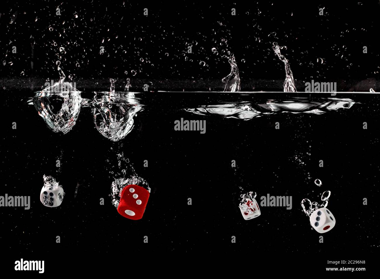 Ludo dice in water splash on black background with lots of air bubbles ...