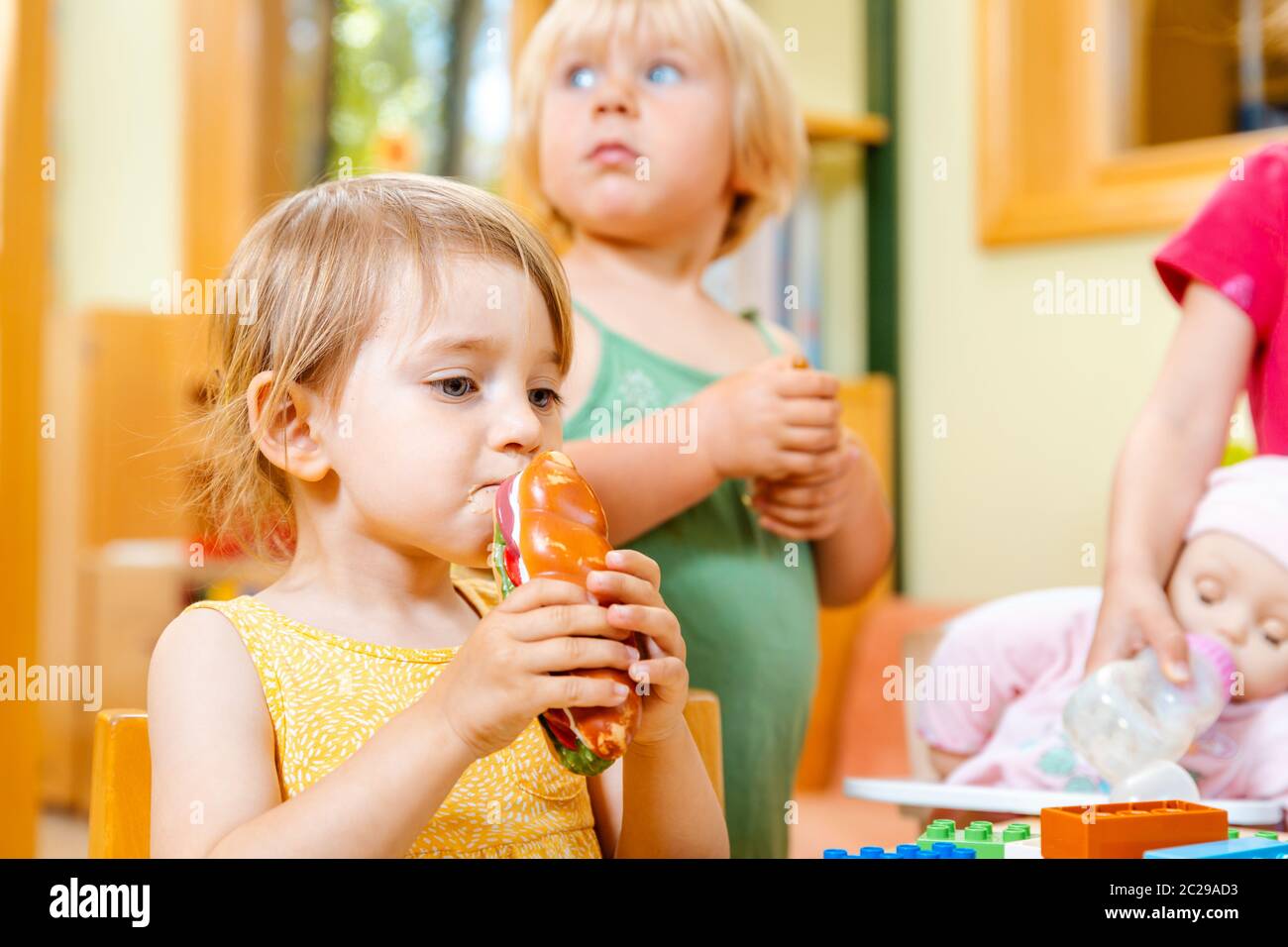 Children eating some food in play school biting in sandwich Stock Photo ...