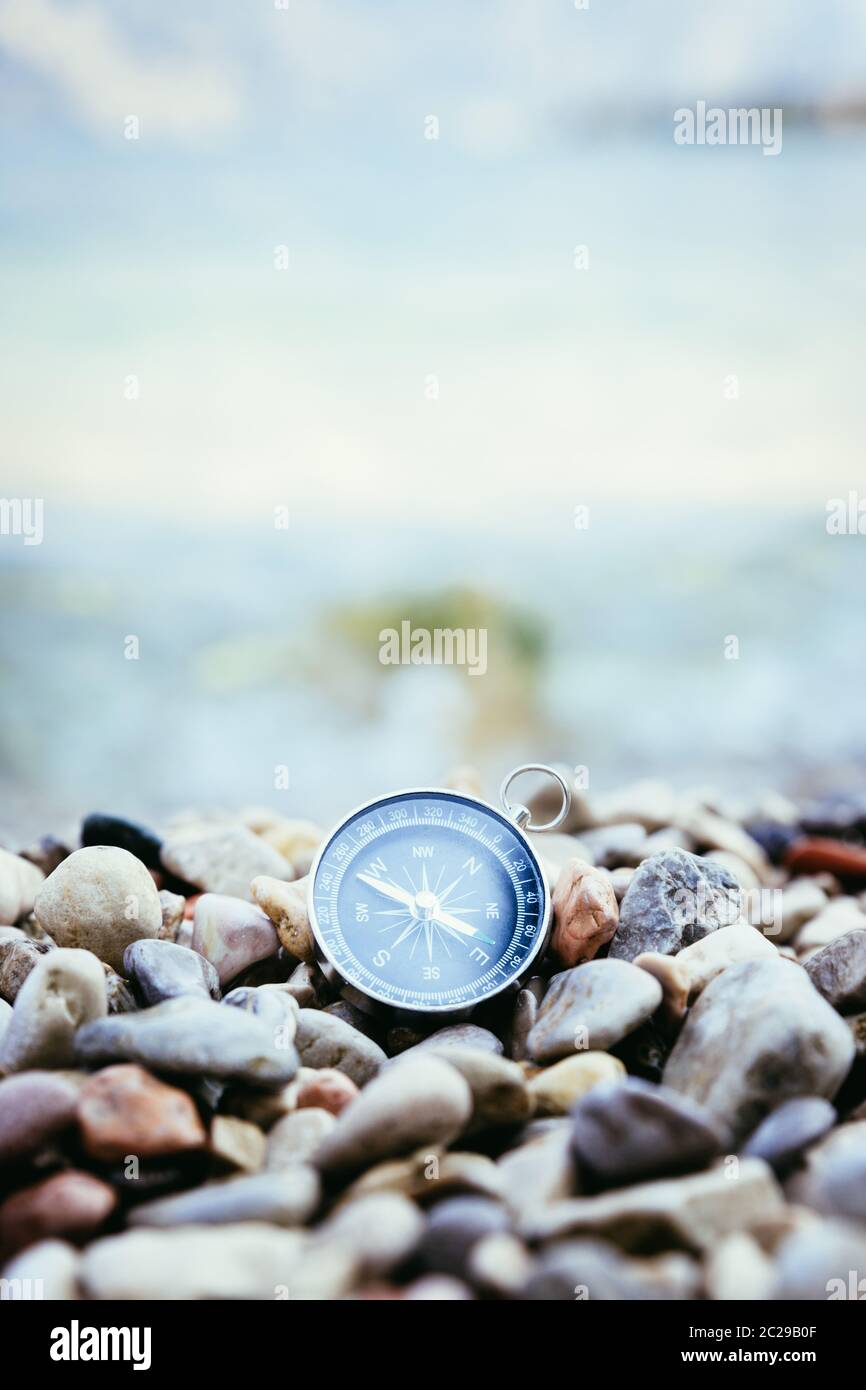 Navigation concept: Compass is lying on the beach near the sea Stock ...