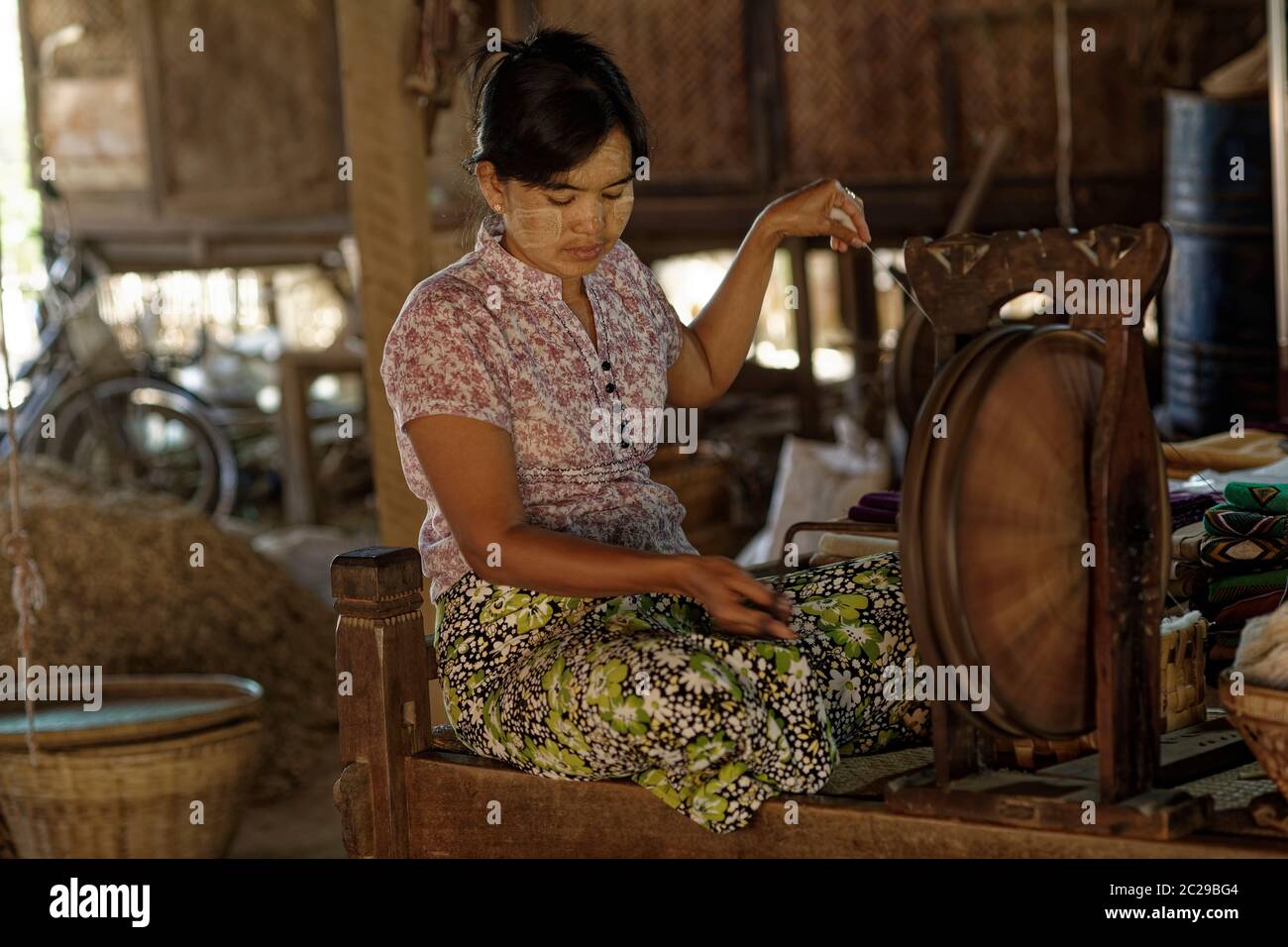 Young woman with spinning wheel, Bagan, Myanmar Stock Photo - Alamy