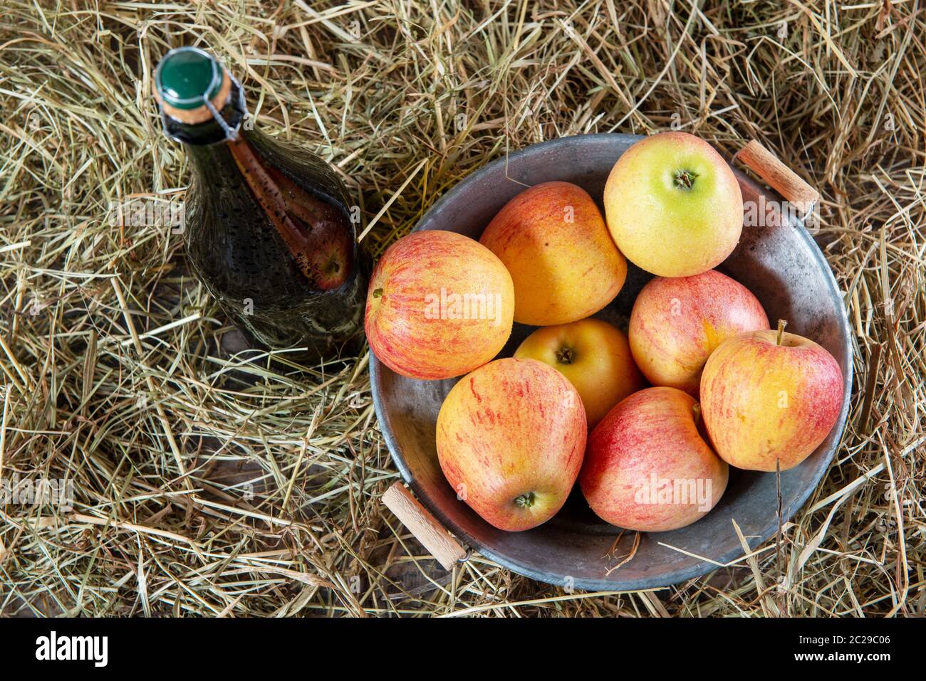 Bottle of cider with organic apples on the straw Stock Photo - Alamy