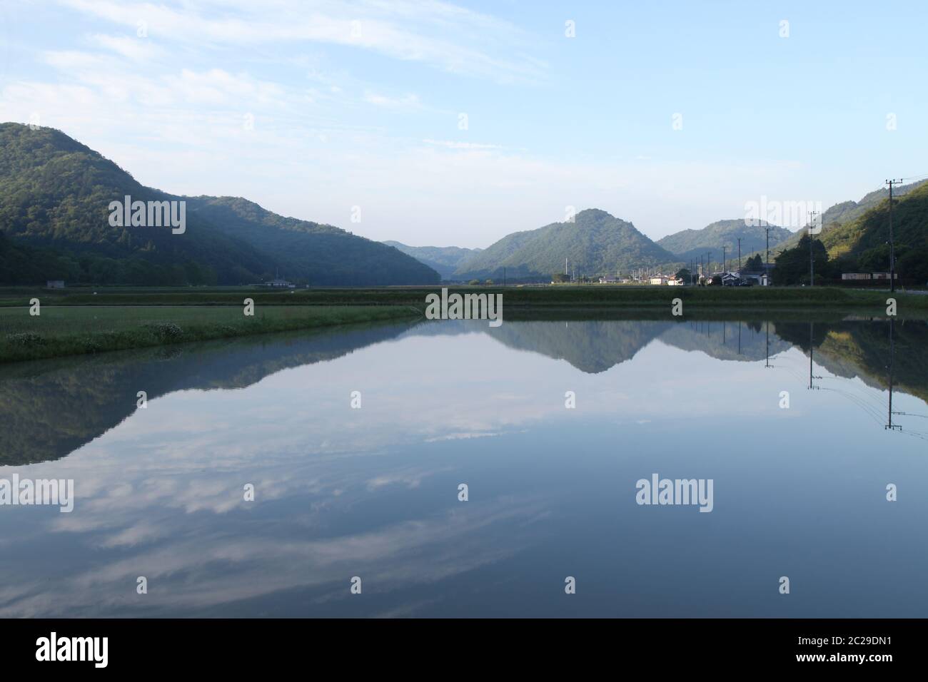 mountains and sky on water mirror of rice paddy field Stock Photo - Alamy