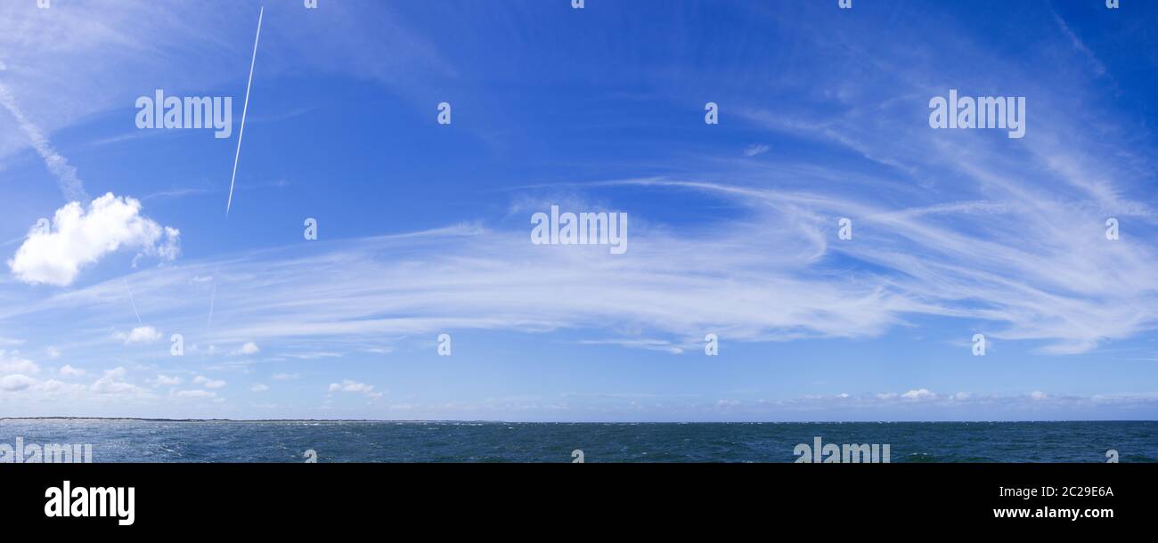 Dynamische Wolken auf blauem Himmel über Nordsee-Panorama Stock Photo ...
