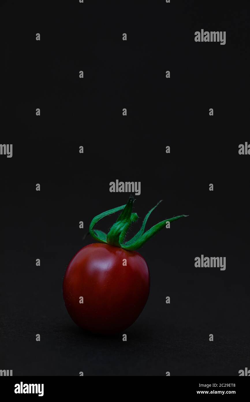 red tomate with green dry leaves Stock Photo - Alamy