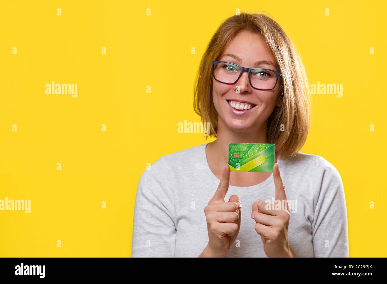 Finance and banking. Young blonde in glasses, with a smile, holding in ...