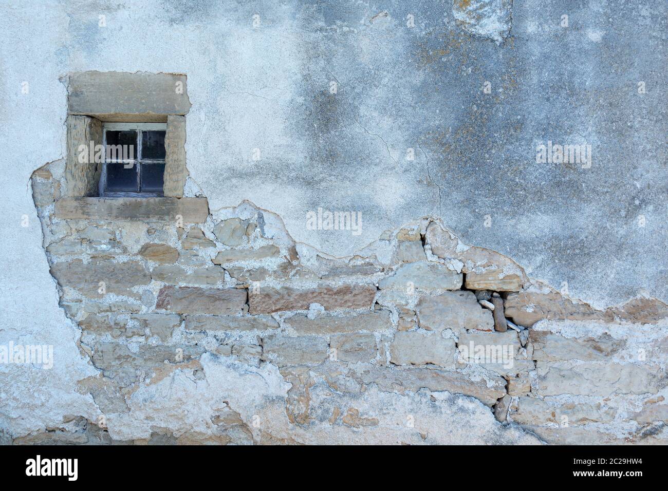 Old rundown house wall with a small window with stone surround Stock ...