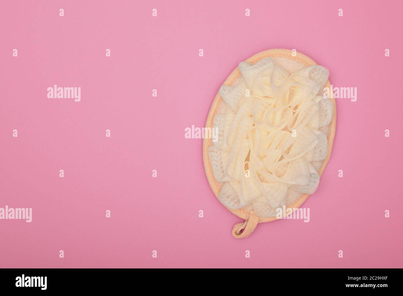 Close up one feminine soft bath shower skin scrub puff over pink ...