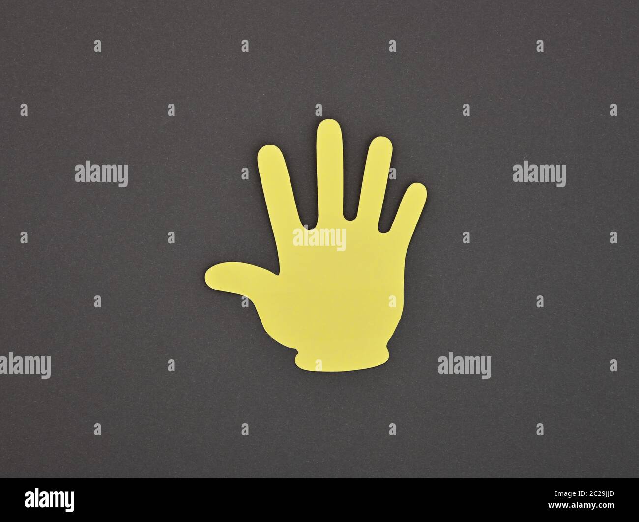 Paper made yellow STOP or HI hand gesture sticker over grey background ...
