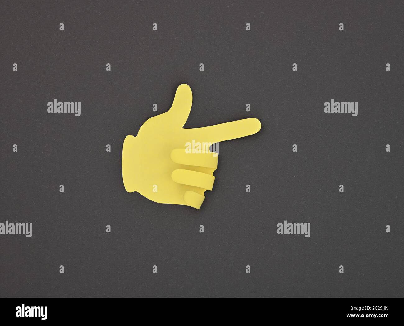 Paper made yellow hand gesture sticker pointing with index finger over ...