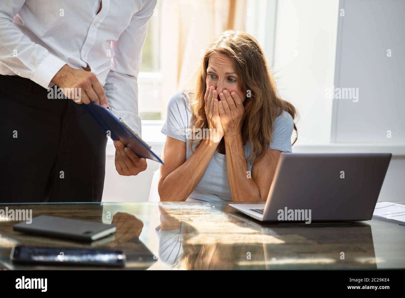 Mature Businesswoman Looking At Report Showing By Her Colleague In ...
