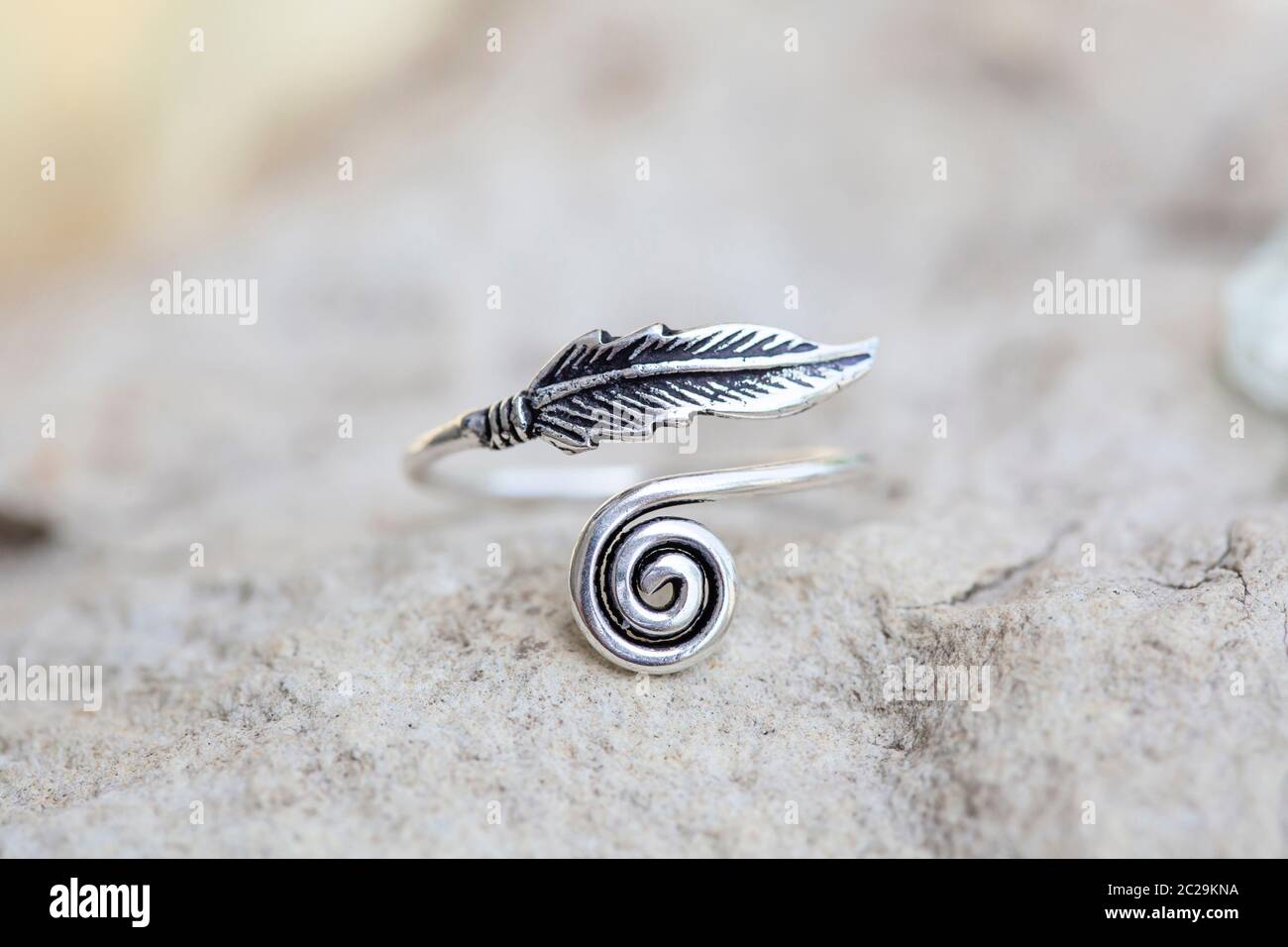 White metal silver ornamental ring with feather shape Stock Photo - Alamy