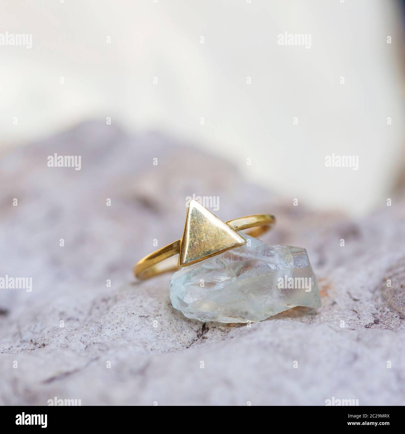Golden metal triangle shape ring on natural neutral background Stock ...