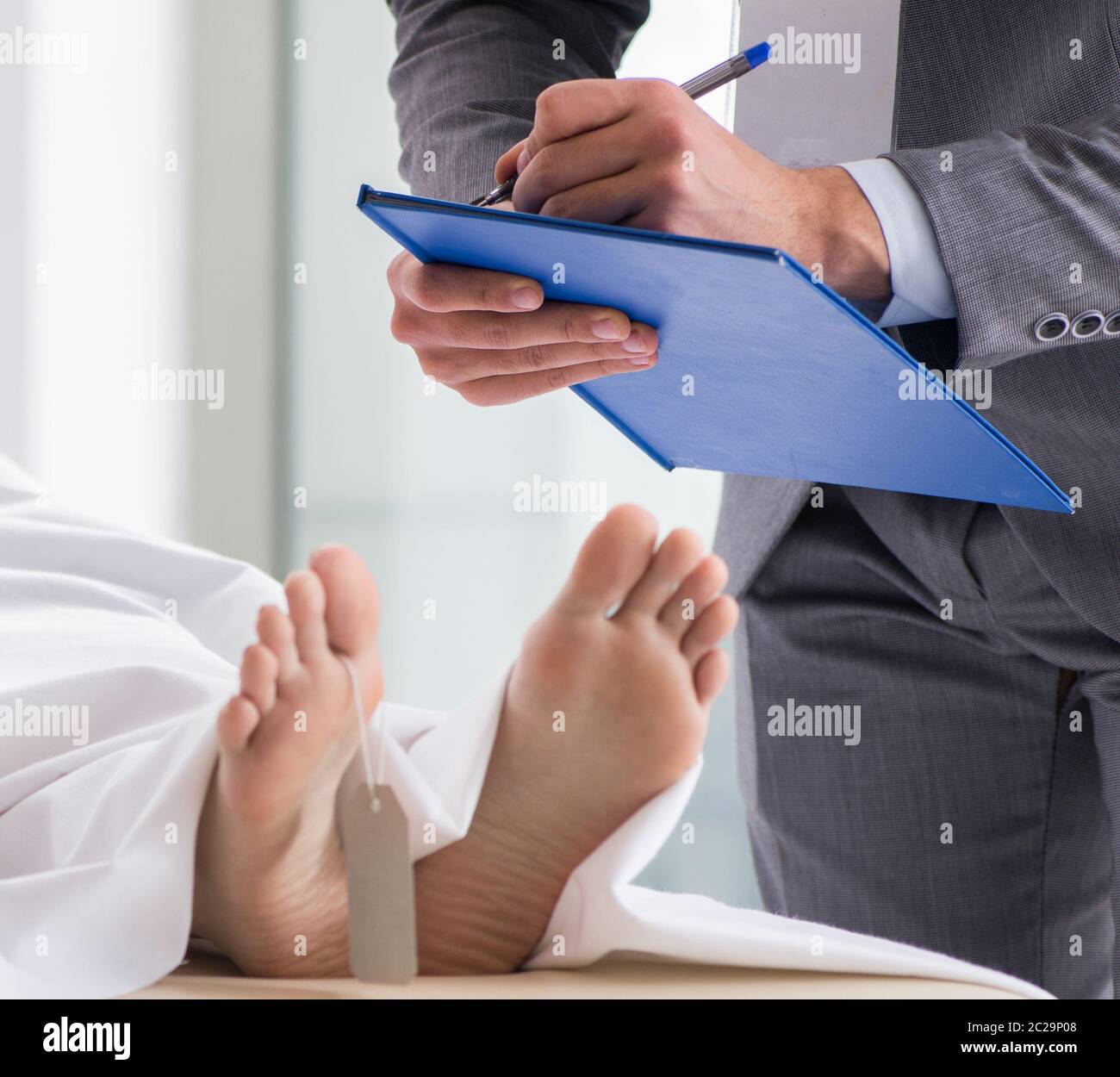 Police coroner examining dead body corpse in morgue Stock Photo - Alamy