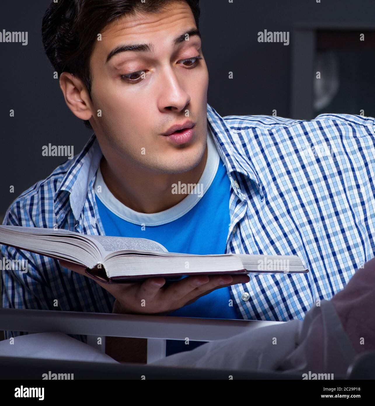 Young student doing homework and looking after newborn baby Stock Photo ...