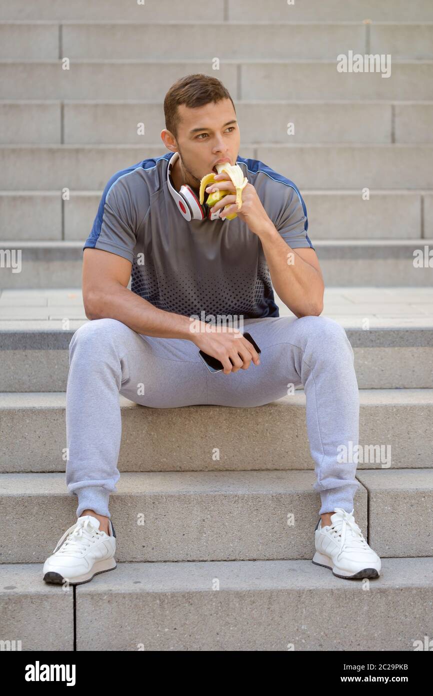 Eating banana fruit runner young man portrait format sports training ...