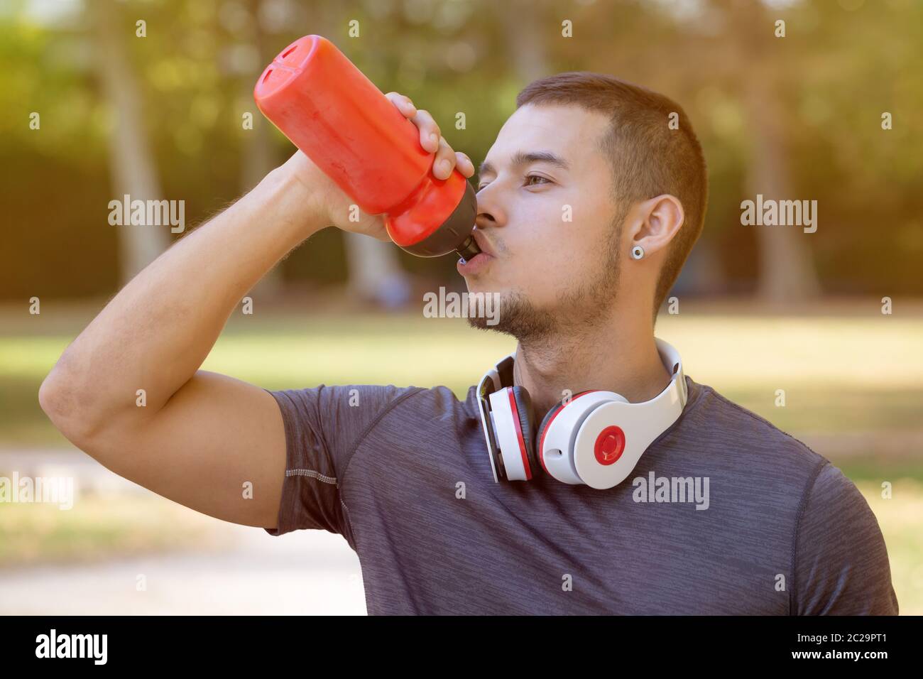 Drinking water runner young man running jogging sports training fitness ...