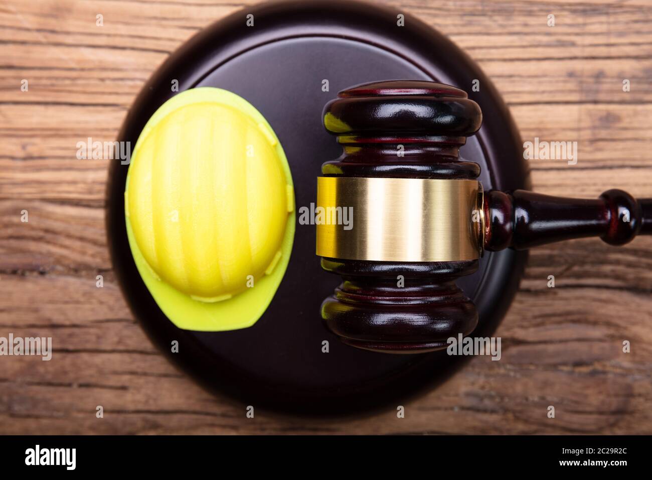 High Angle View Of Yellow Hard Hat And Gavel Arranged On Wooden Desk ...