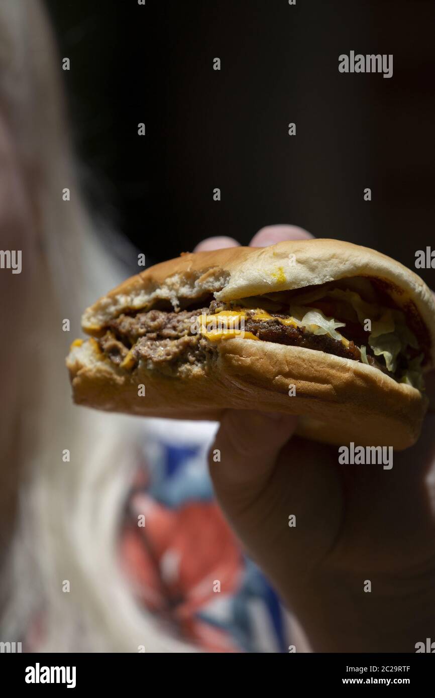 Albino woman eating a double meat cheese burger Stock Photo - Alamy