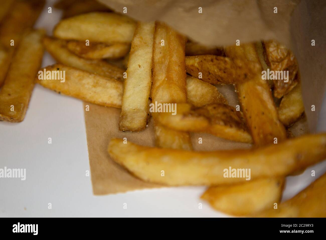 Golden fried french fries in brown paper wrapping Stock Photo - Alamy