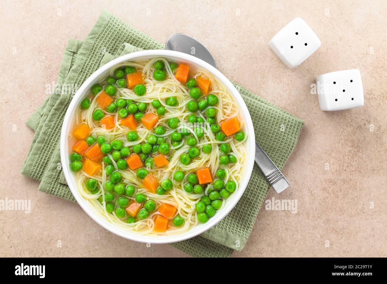 Fresh homemade vegetable noodle soup with carrot, peas, onion and angel ...