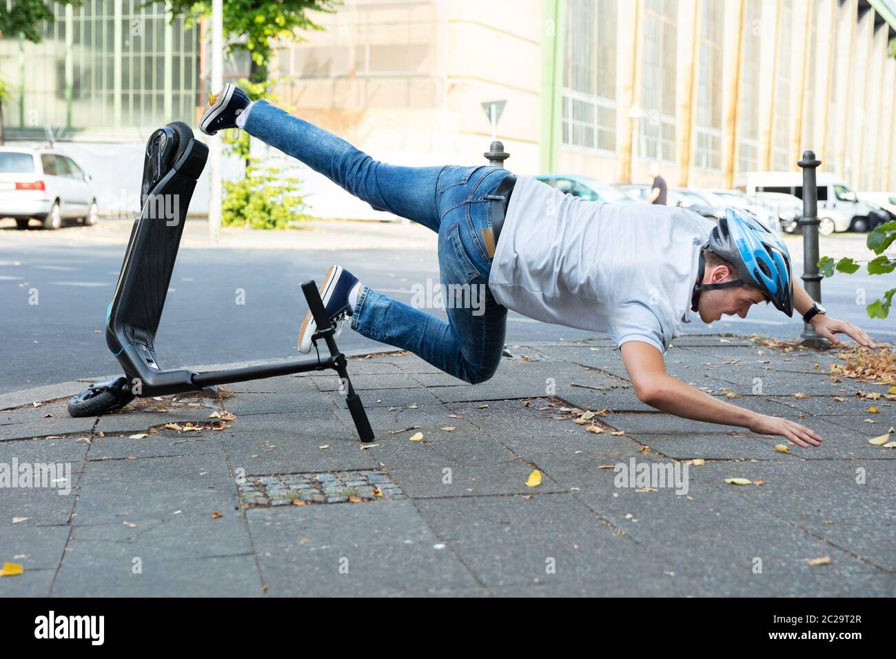 Man Having Accident Falling From E-Scooter On Street Stock Photo - Alamy