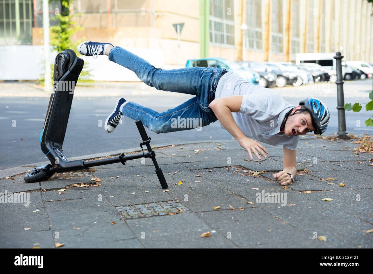 Man Having Accident Falling From E-Scooter On Street Stock Photo - Alamy