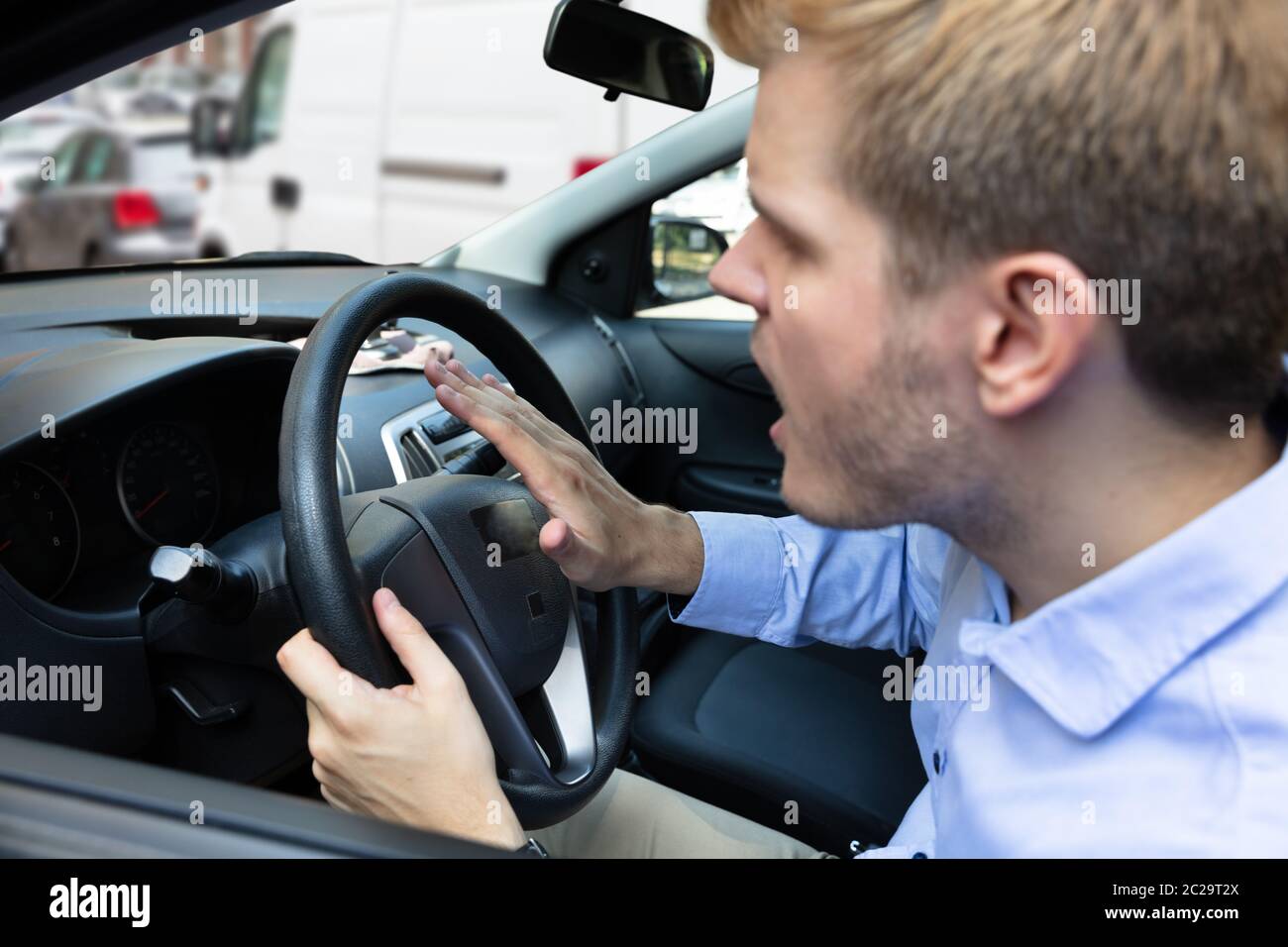 Angry Driver Pressing Horn And Screaming While Driving Stock Photo - Alamy