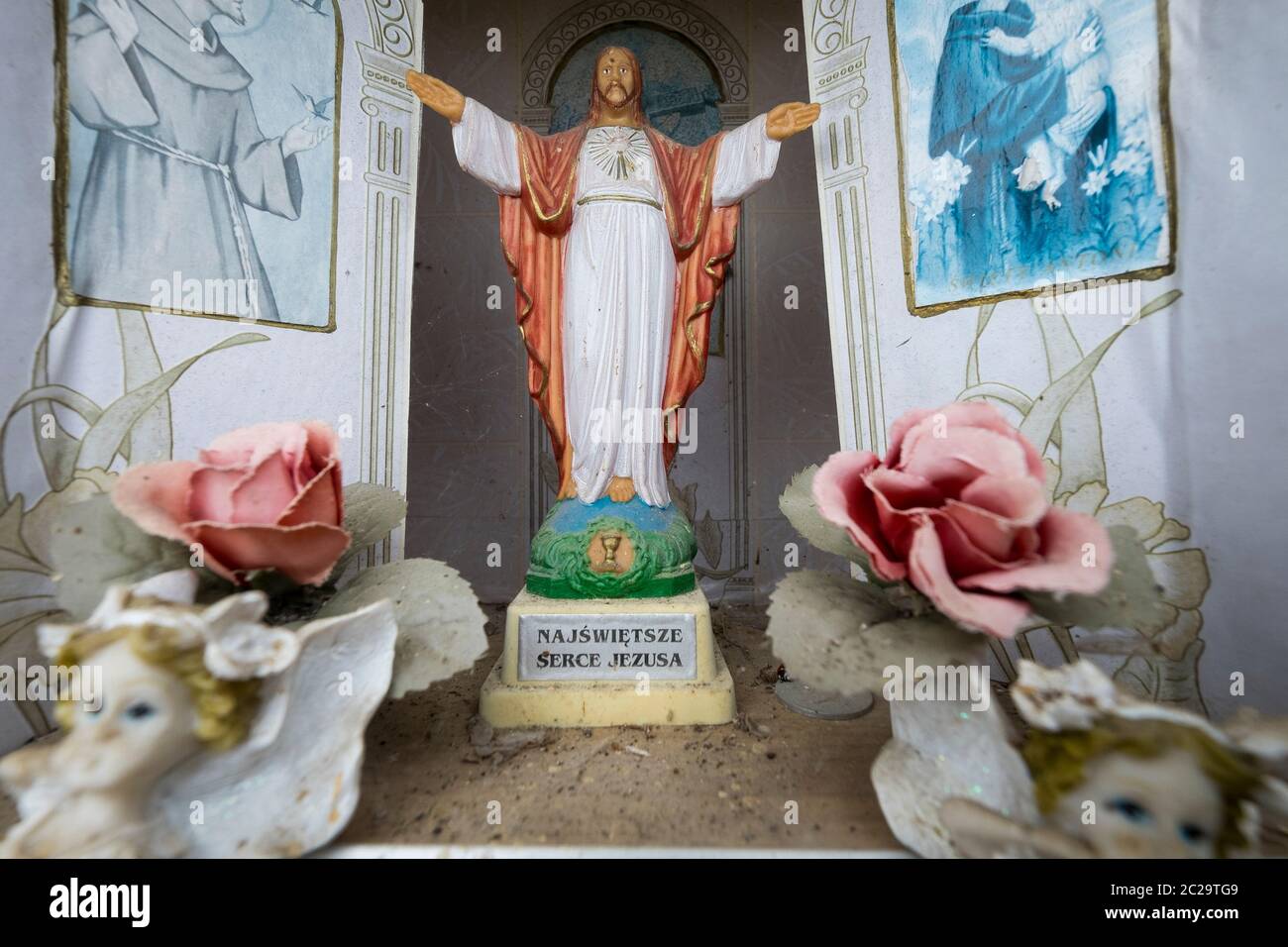 A diorama of an outstretched Jesus with roses and angels. A religious ...