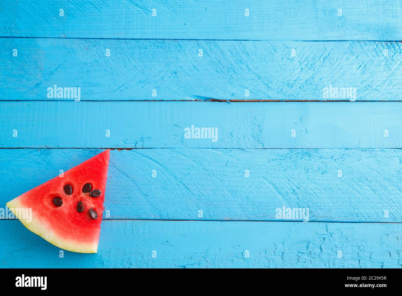 red scarlet watermelon pieces on blue wooden vintage background. summer ...
