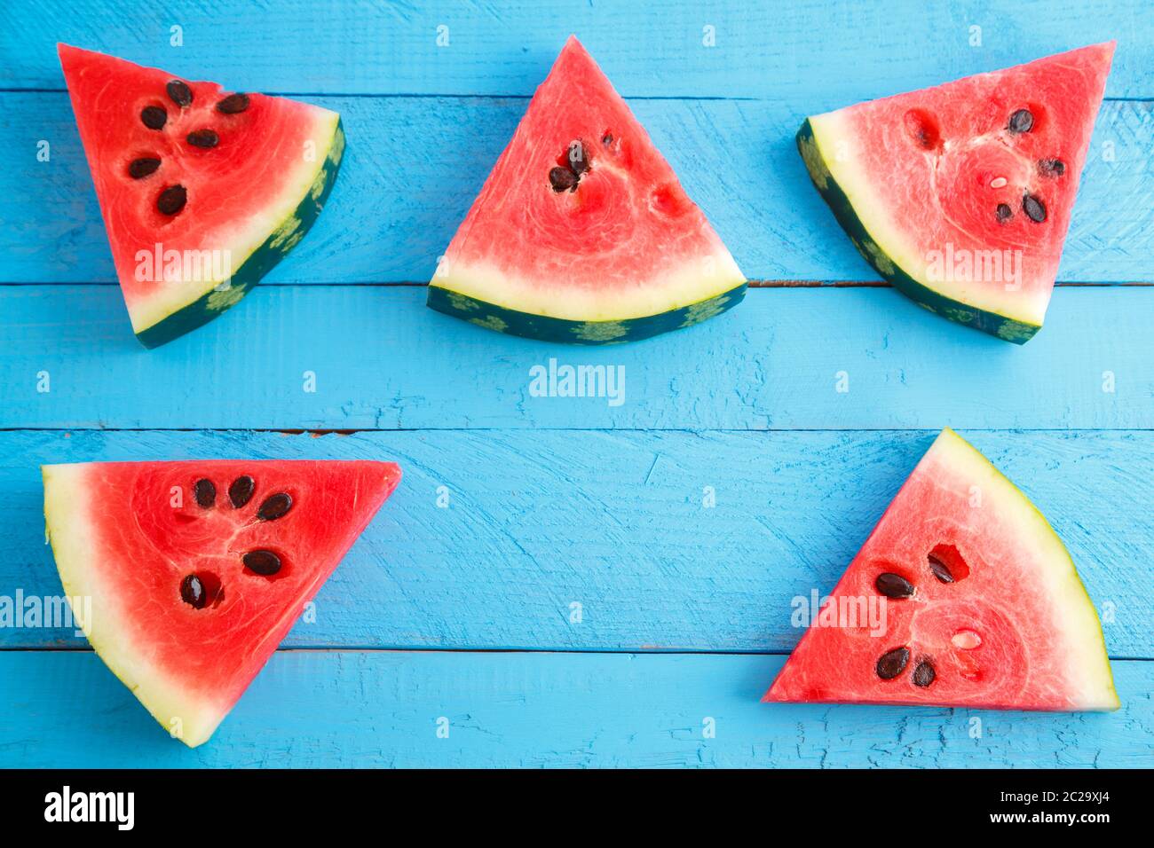 red scarlet watermelon pieces on blue wooden vintage background. summer ...